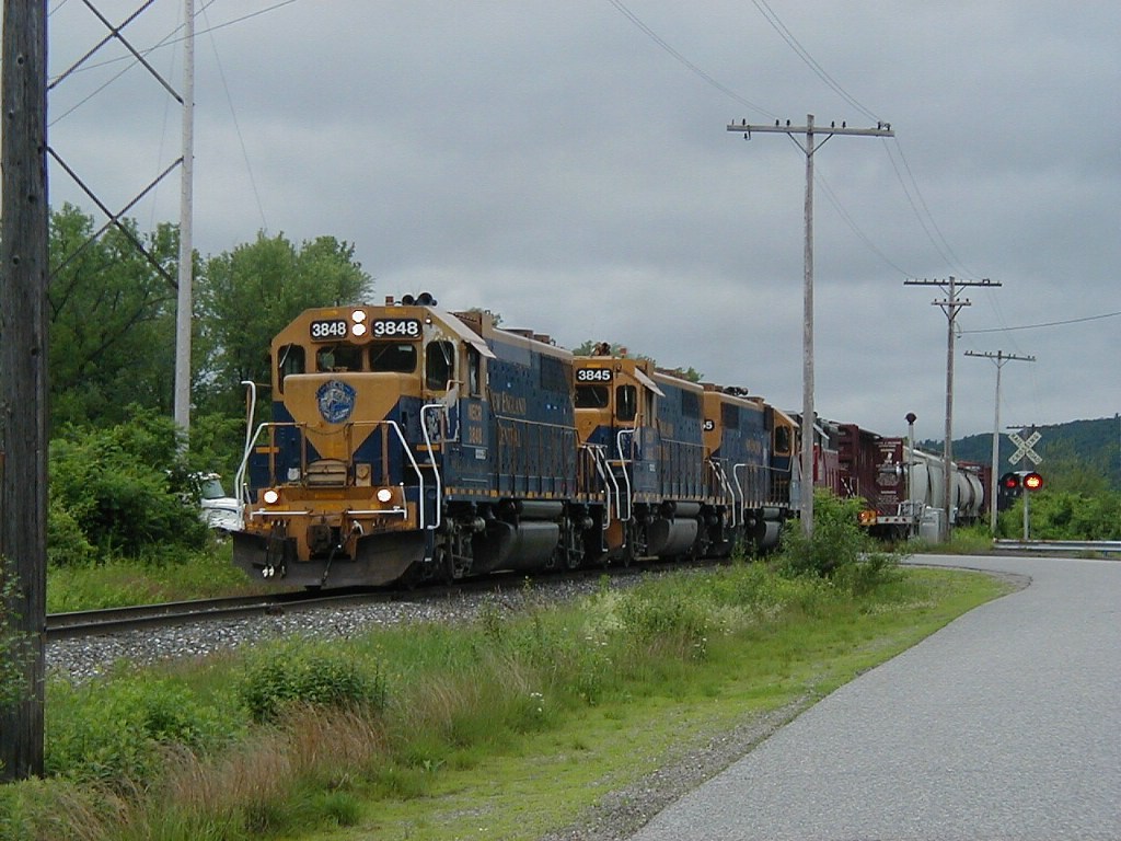 NECR 3848 leading an all NECR locomotive consist & freight train slowly into the yard